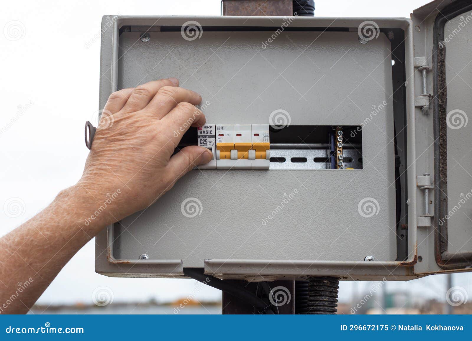 A Man Switches the Toggle Switches of the Electrical Panel on the Pole ...