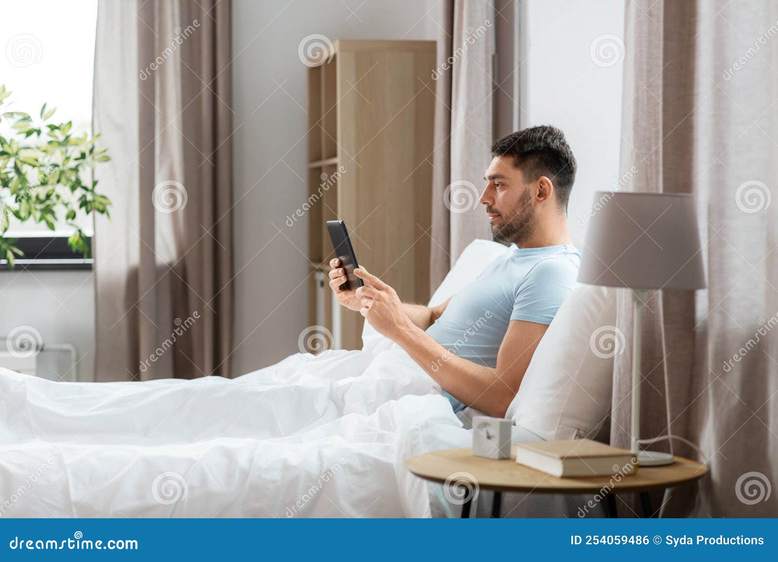 Man with Tablet Computer in Bed at Home Bedroom Stock Photo - Image of ...