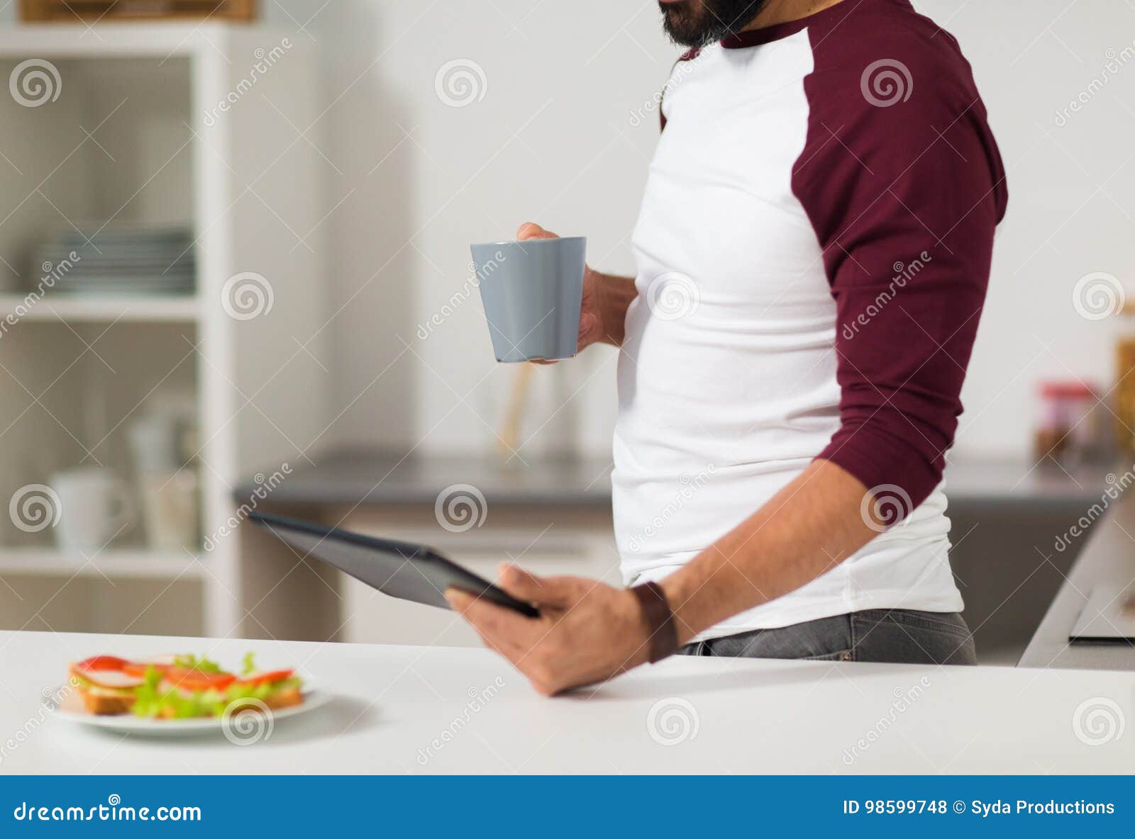Man with Tablet Pc Eating at Home Kitchen Stock Photo - Image of ...