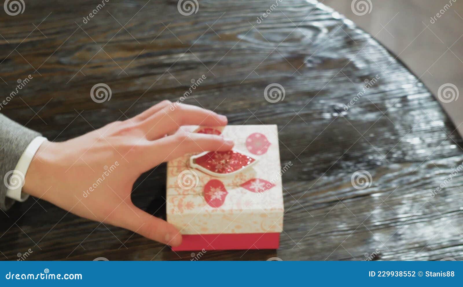 A Man Takes a Gift Box from Under the Table and Puts it on the Table in ...