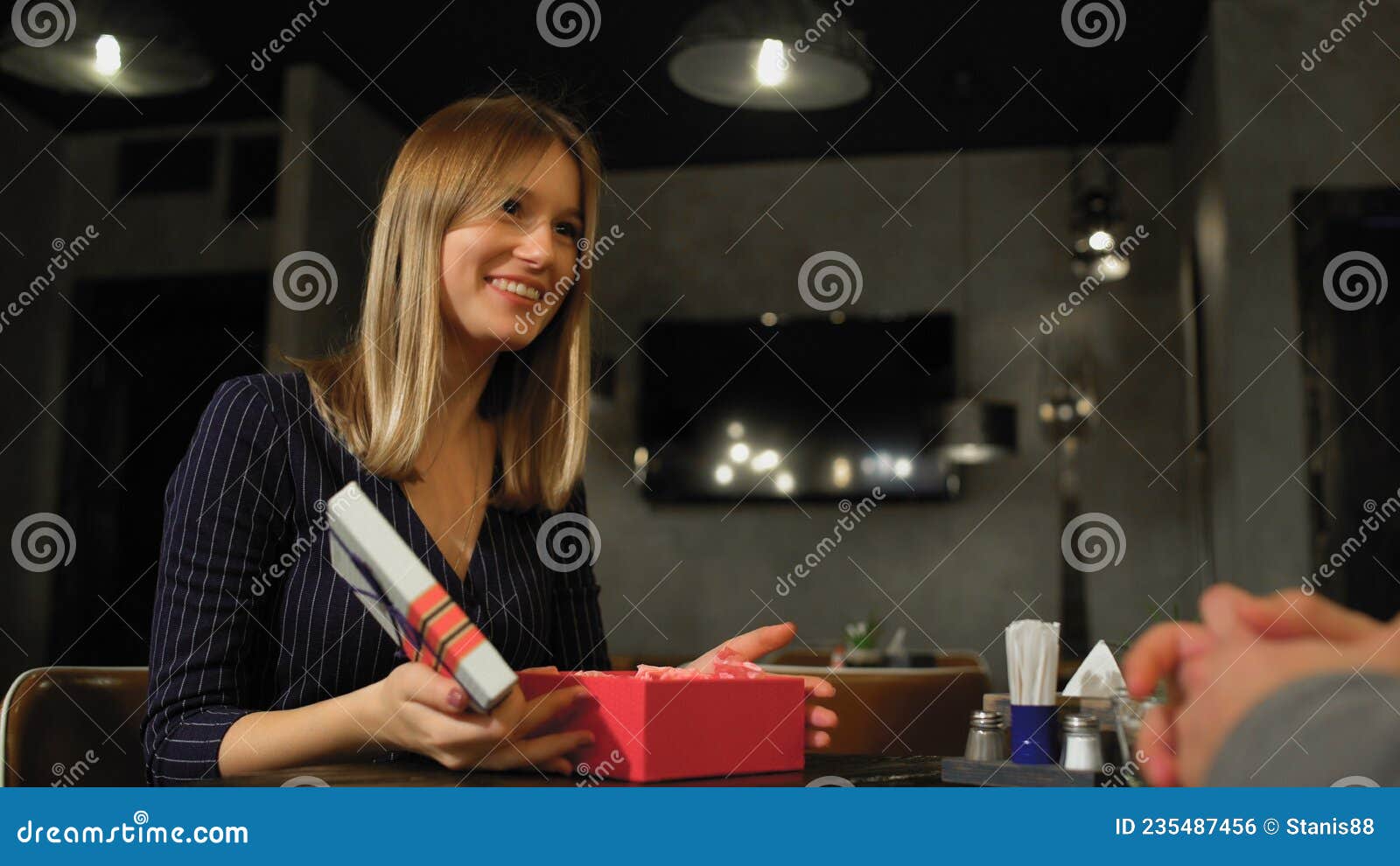 A Man Takes a Gift Box from Under the Table and Puts it on the Table in ...