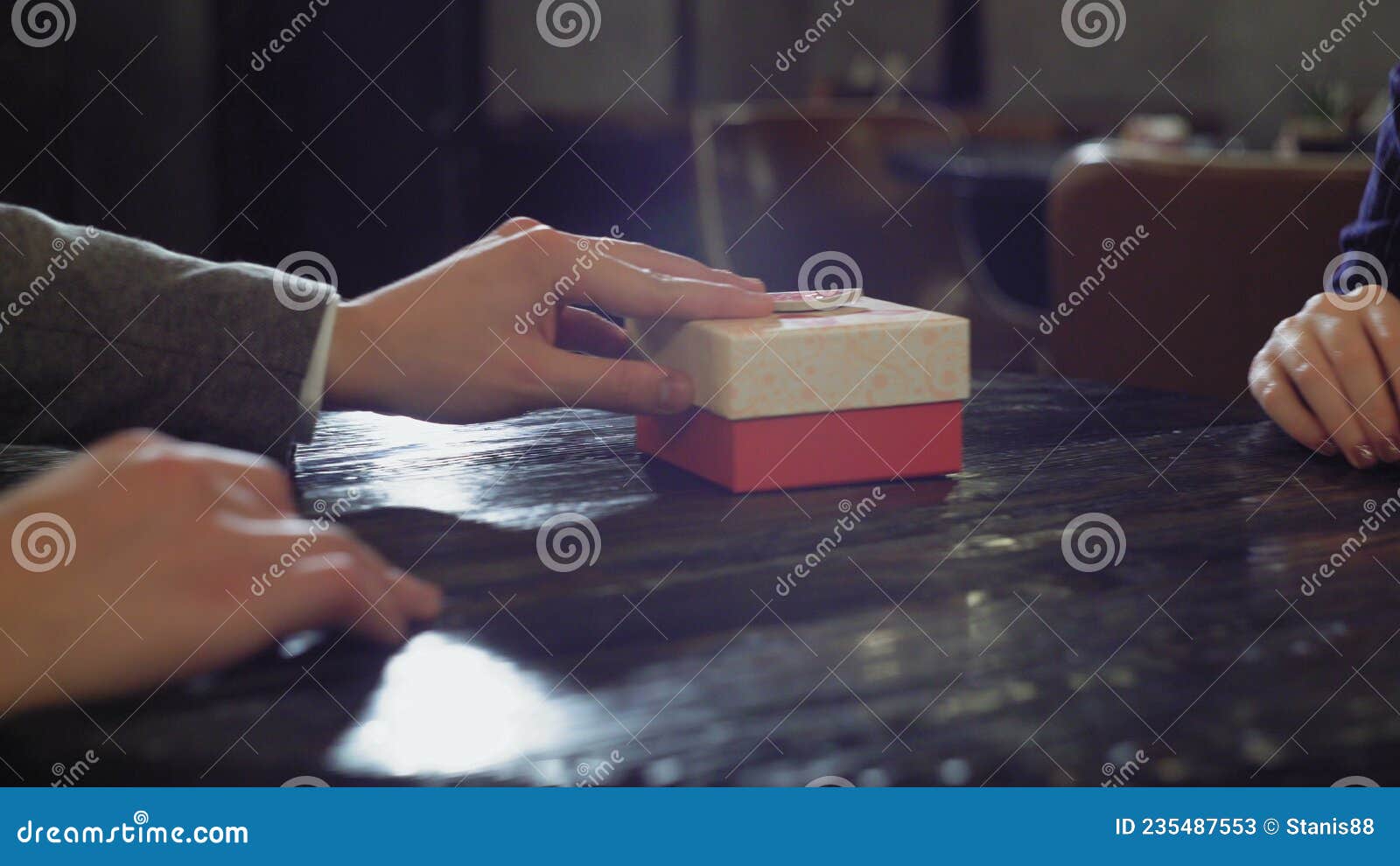 A Man Takes a Gift Box from Under the Table and Puts it on the Table in ...