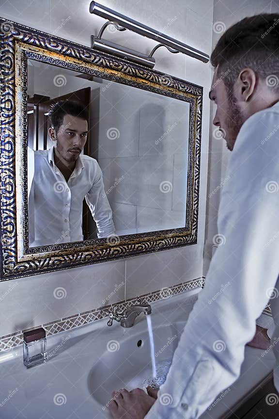 Man Takes a Look at Himself in the Mirror. Stock Photo - Image of ...