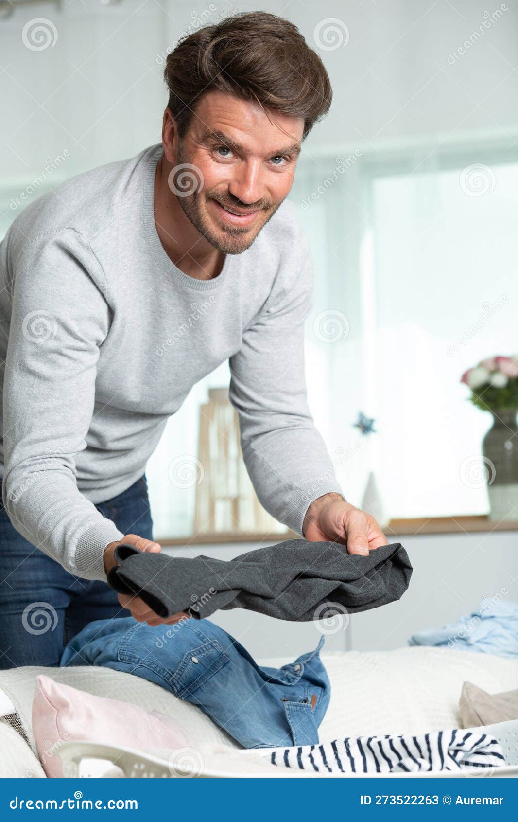 Man Taking Clothes from Rack and Putting Them To Basket Stock Image ...