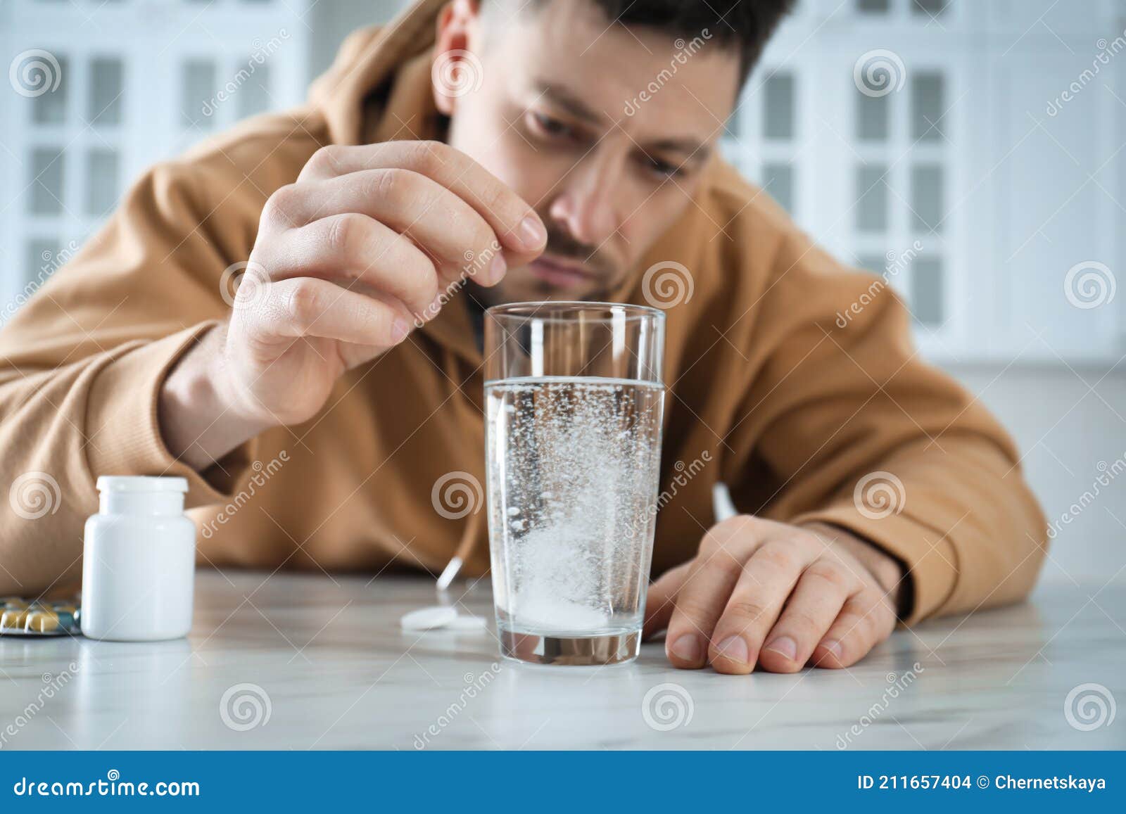 Man Taking Medicine for Hangover at Table in Kitchen Stock Photo ...