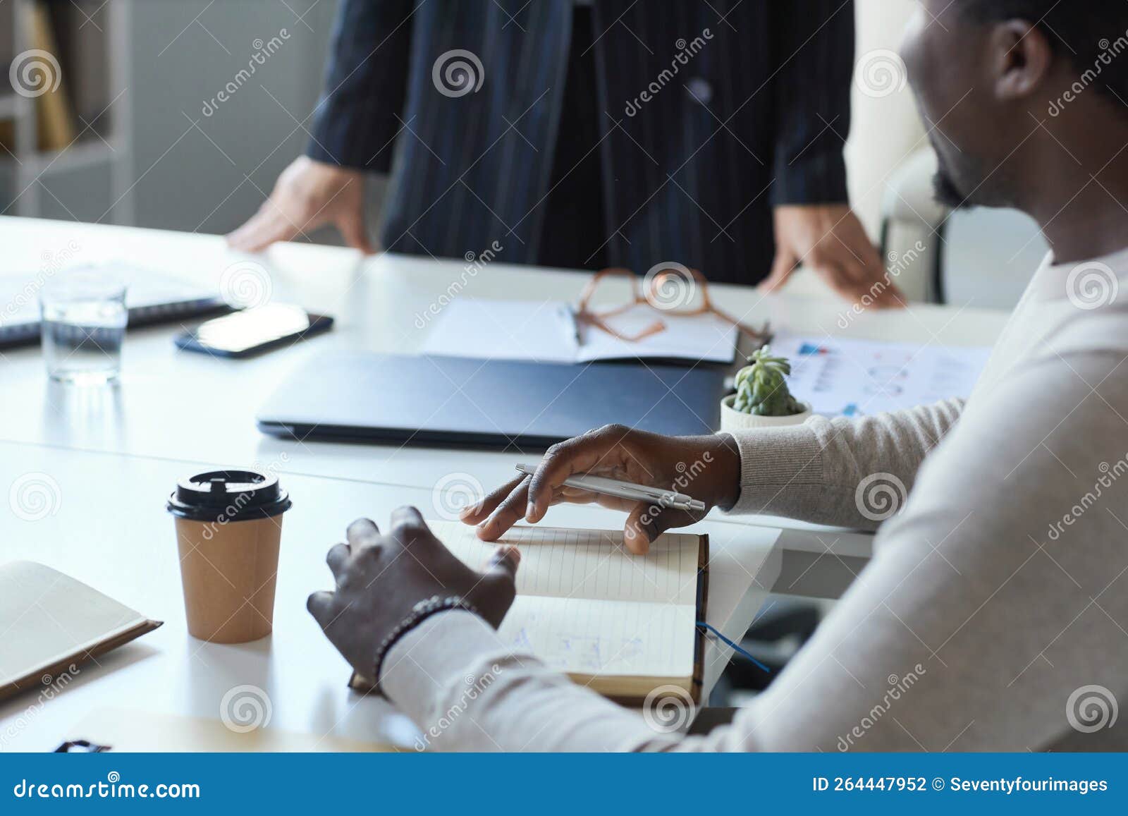 Man Taking Notes in Planner during Business Meeting with Team Stock ...