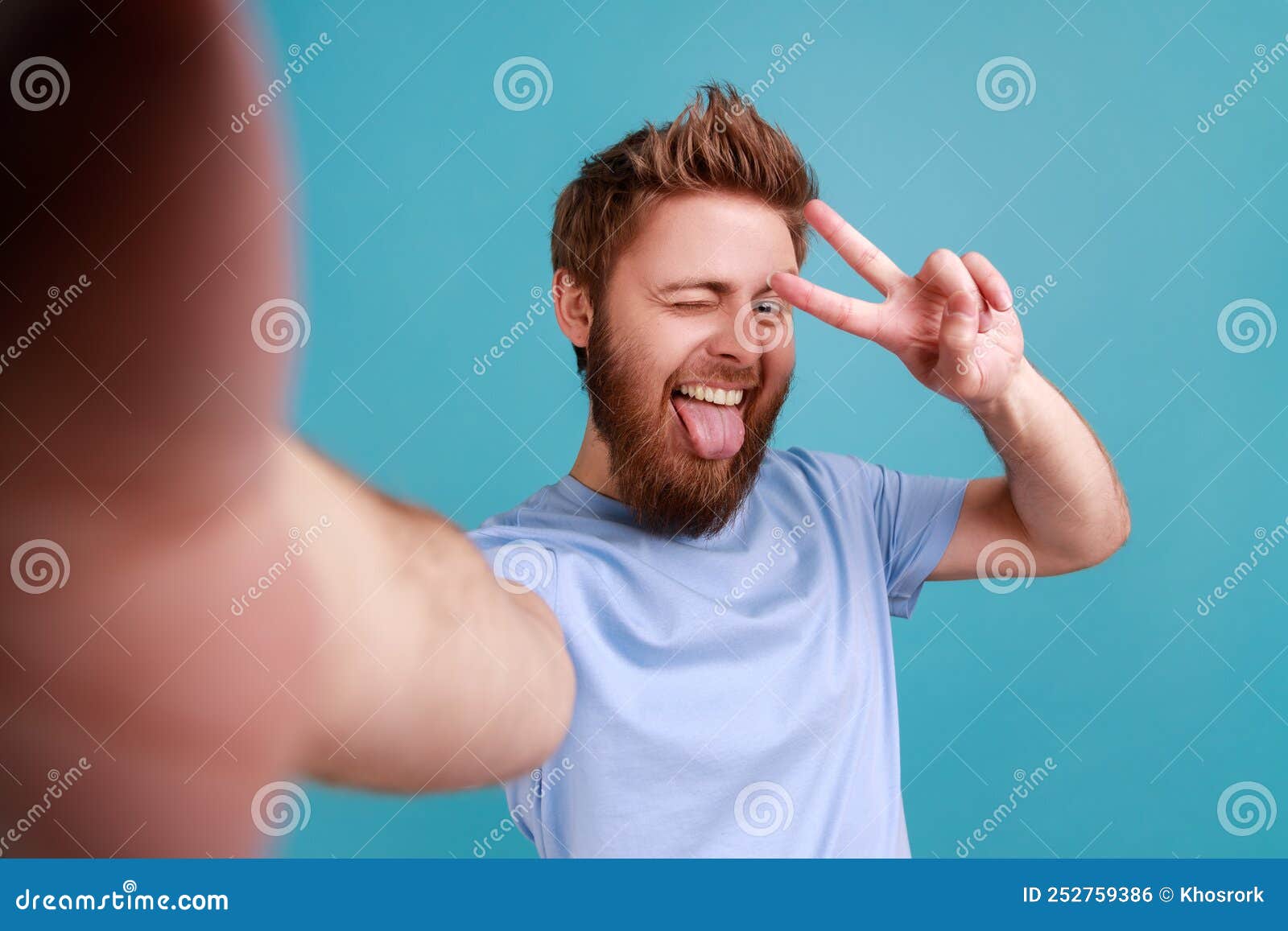Man Taking Selfie Looking At Camera Pov Point Of View Of Photo Showing Victory Gesture Tongue