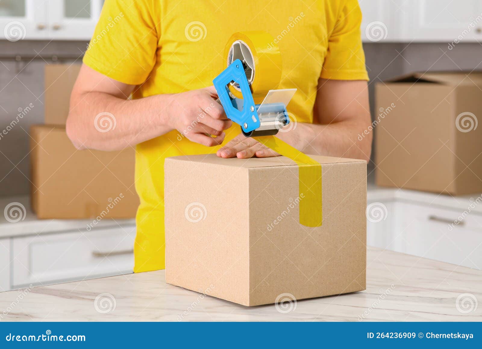 Man Taping Box with Adhesive Tape Dispenser in Kitchen, Closeup Stock ...