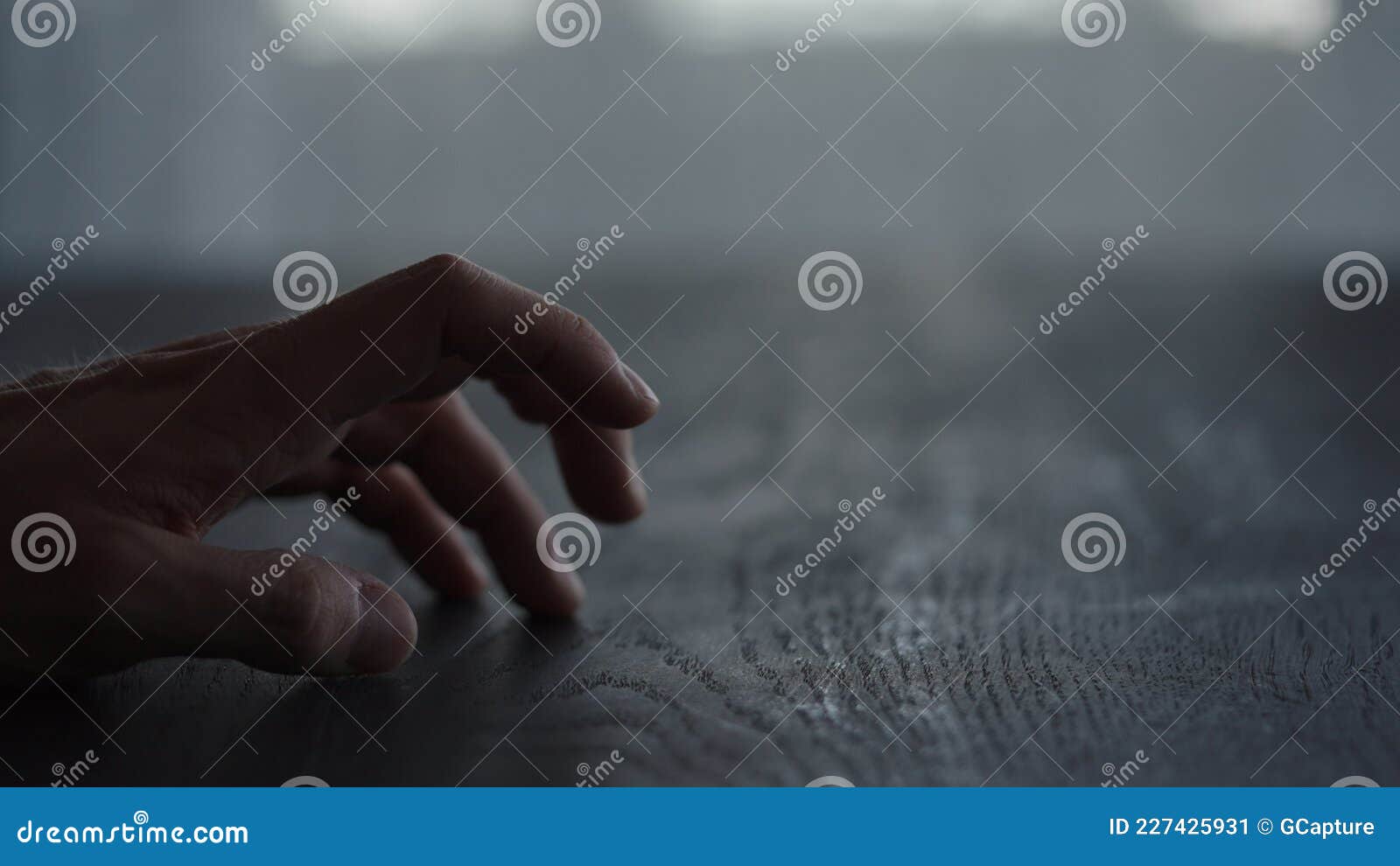 Man Tapping Fingers on Black Oak Table with Back Light Stock Image ...
