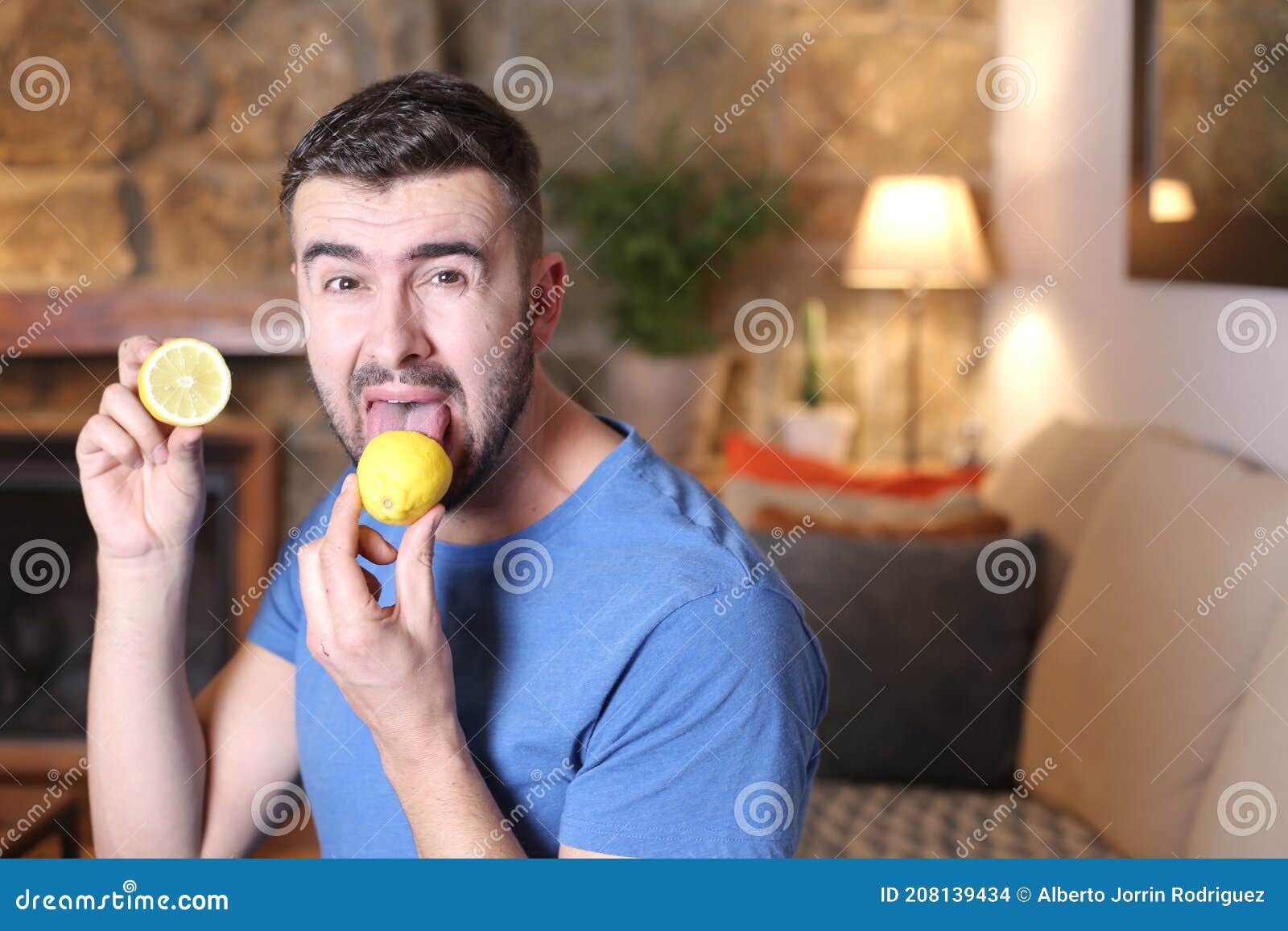 Man tasting a raw lemon stock photo. Image of acid, lifestyle - 208139434