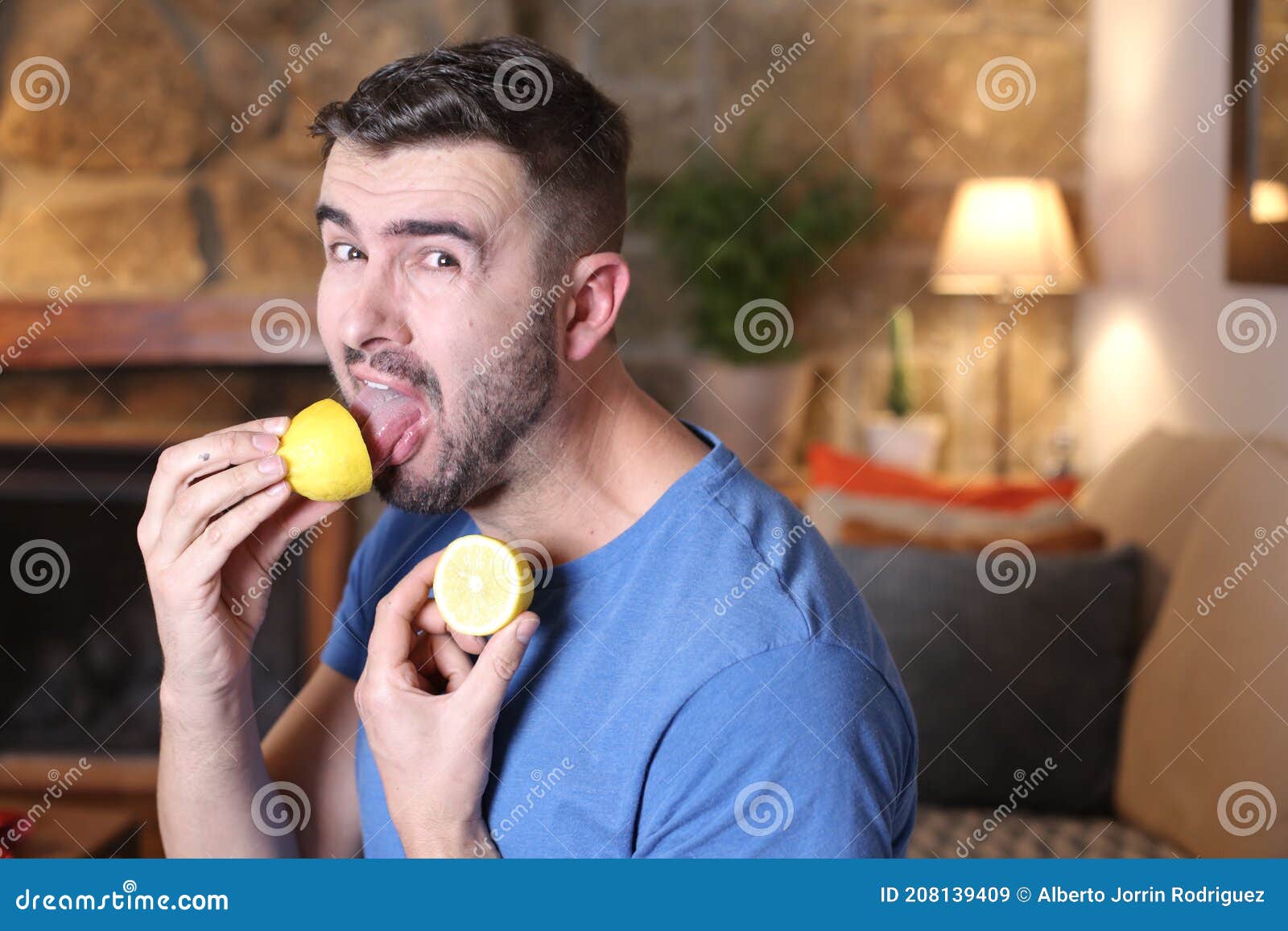Man tasting a raw lemon stock image. Image of eating - 208139409