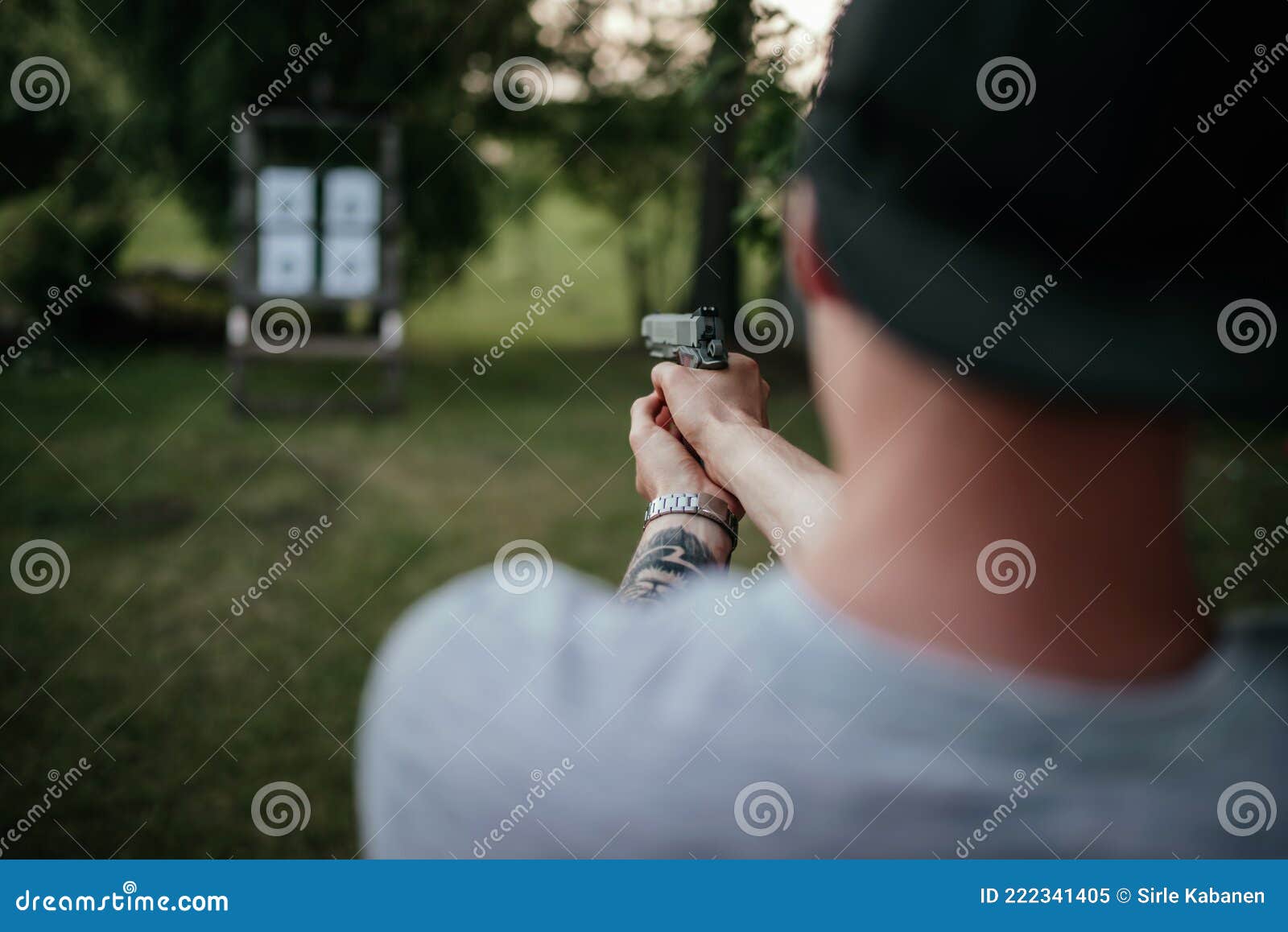 Man with Tattoos Holding Gun and Shooting Target. Back View Stock Image ...