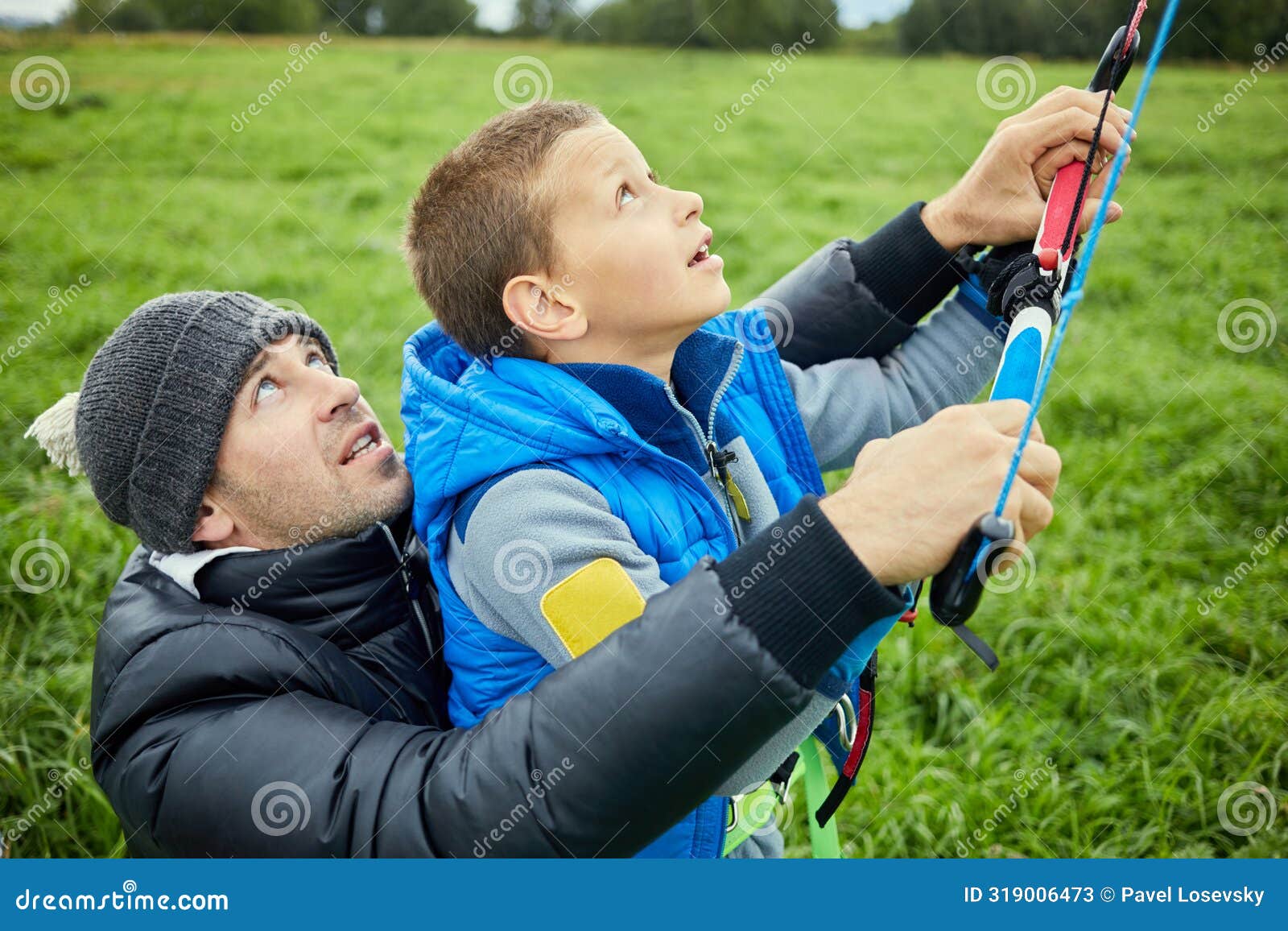 Man Teaches Boy To Control Power Kite on Green Stock Image - Image of ...