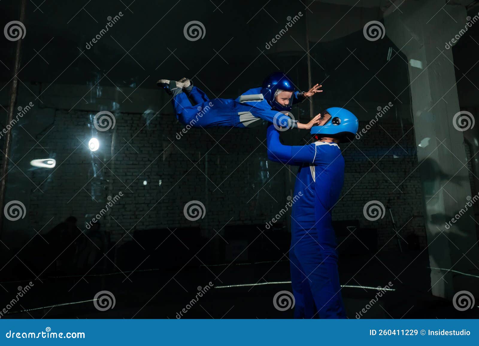 A Man Teaches a Boy To Fly in a Wind Tunnel. Lack of Gravity. Stock ...