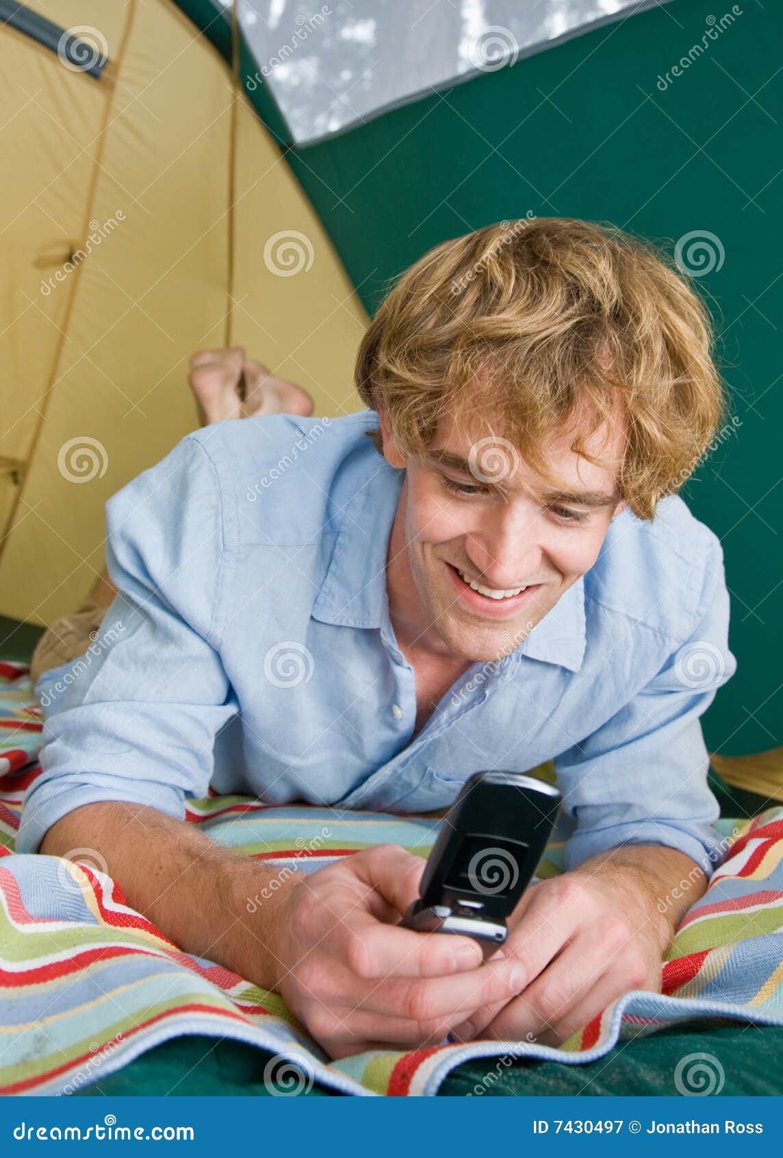 Man in Tent Text Messaging on Cell Phone Stock Image - Image of inside ...