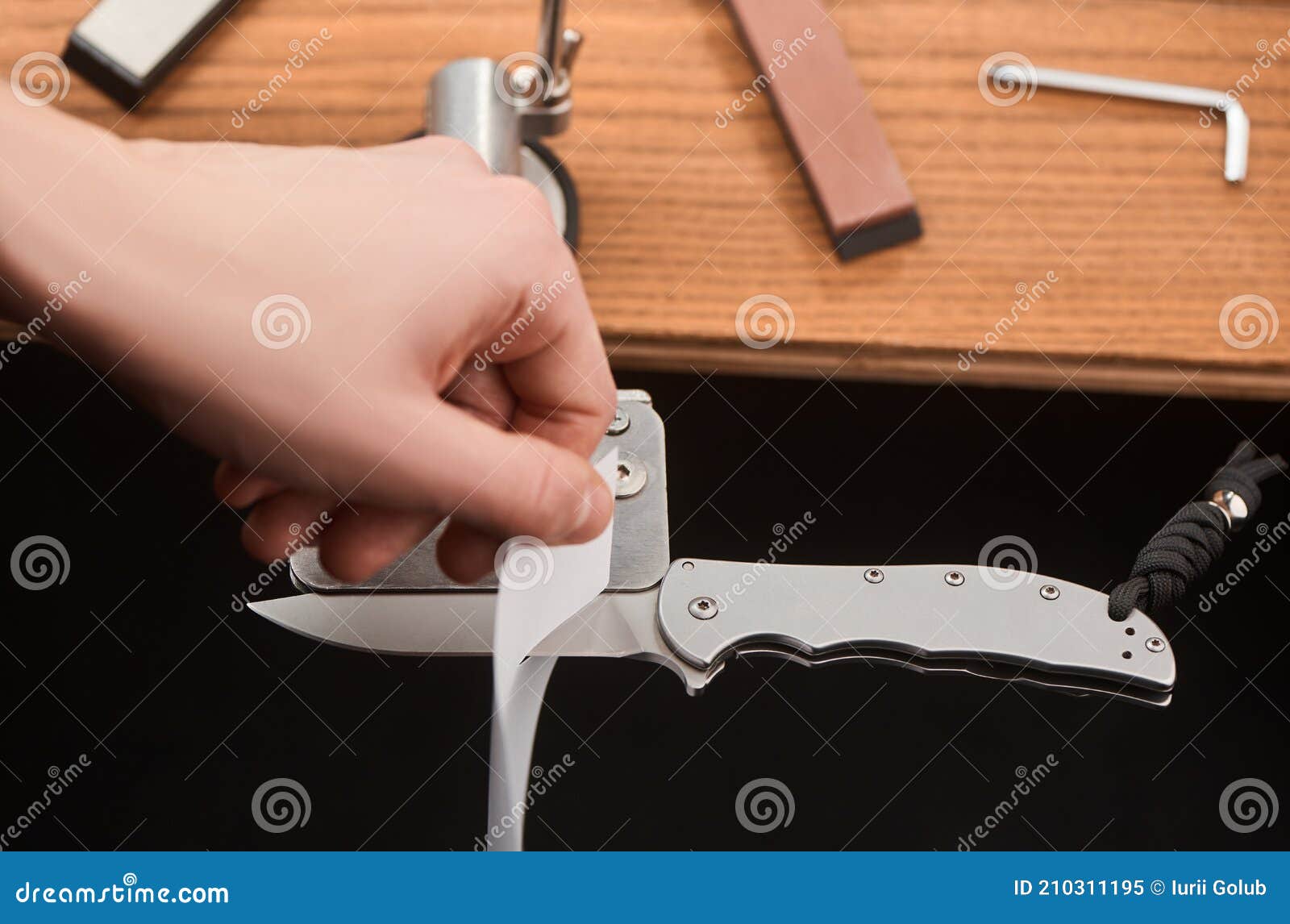 Man Testing the Blade of a Folding Knife with a Paper Sheet Stock Image ...