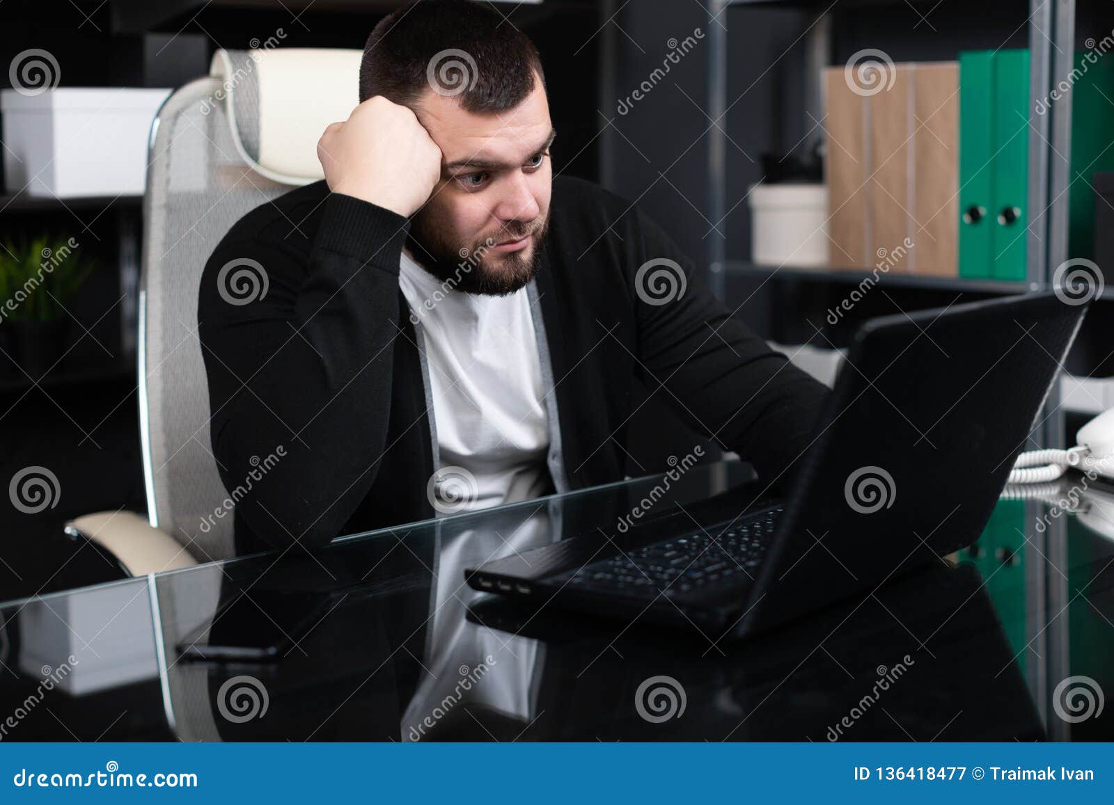 Portrait of Young Man Propping Up His Head with His Fist with Laptop in ...