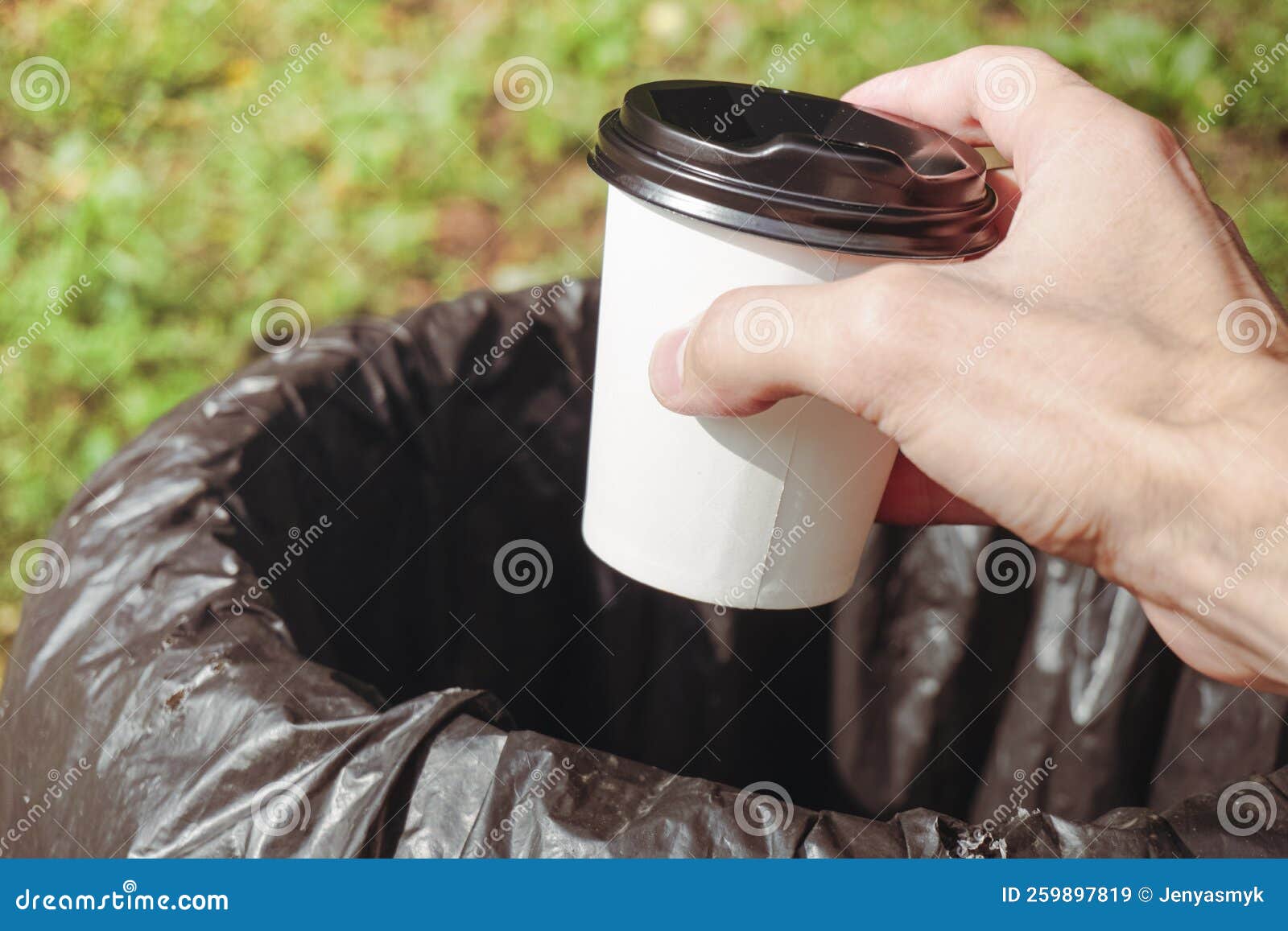 Man Throwing Coffee Cup into Bin Outdoors. a Hand Throws a Paper Cup ...