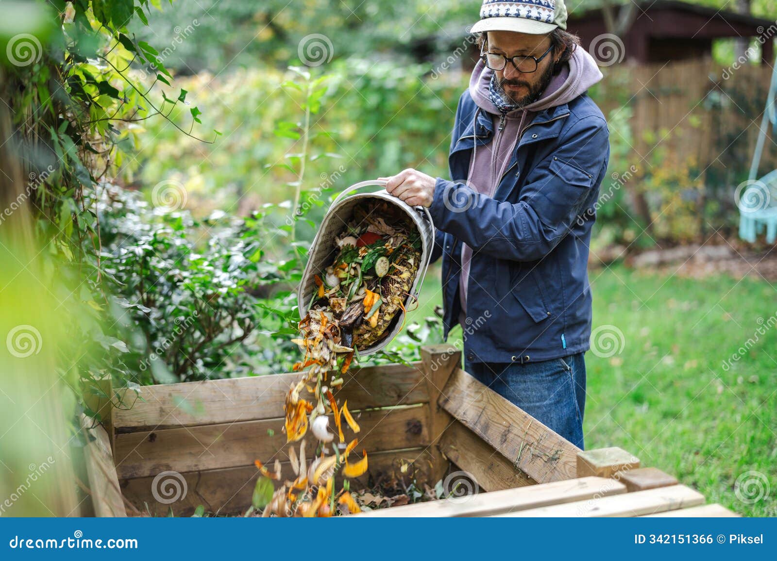 Man Throwing Vegetable Scraps into a Compost Container in the Backyard ...