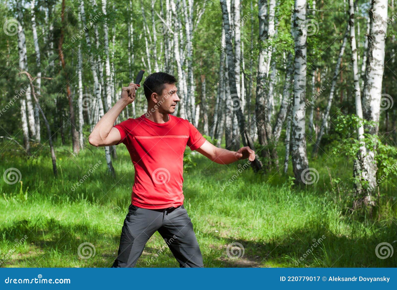 A Man Throws a Knife at a Target in the Summer Forest, Side View ...