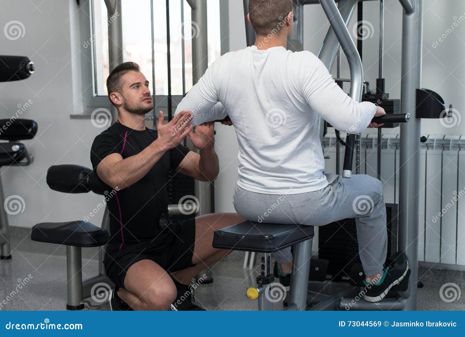 Man Train Back on Machine with Personal Trainer Stock Image - Image of ...
