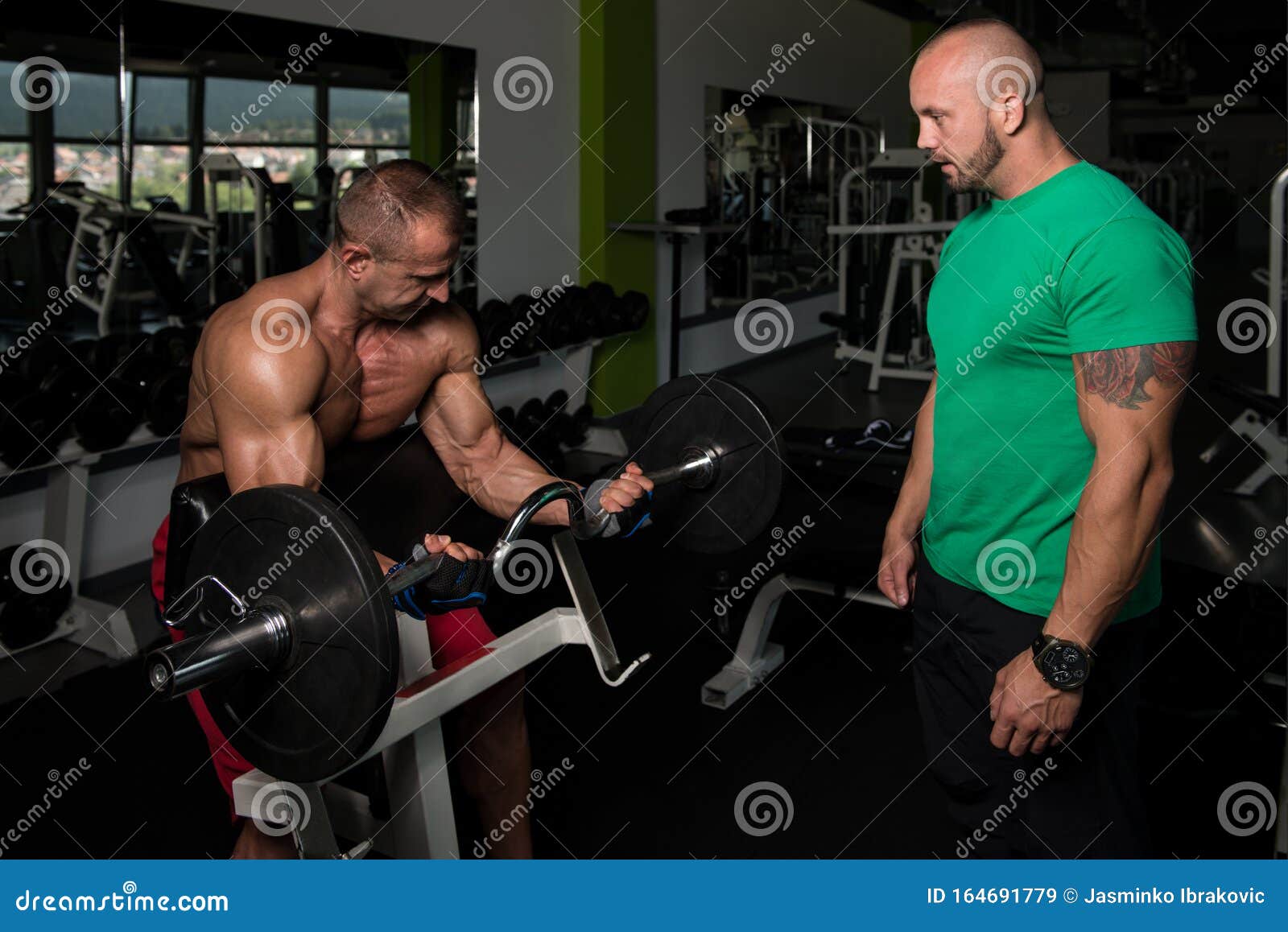 Man Train Biceps on Machine with Personal Trainer Stock Image - Image ...