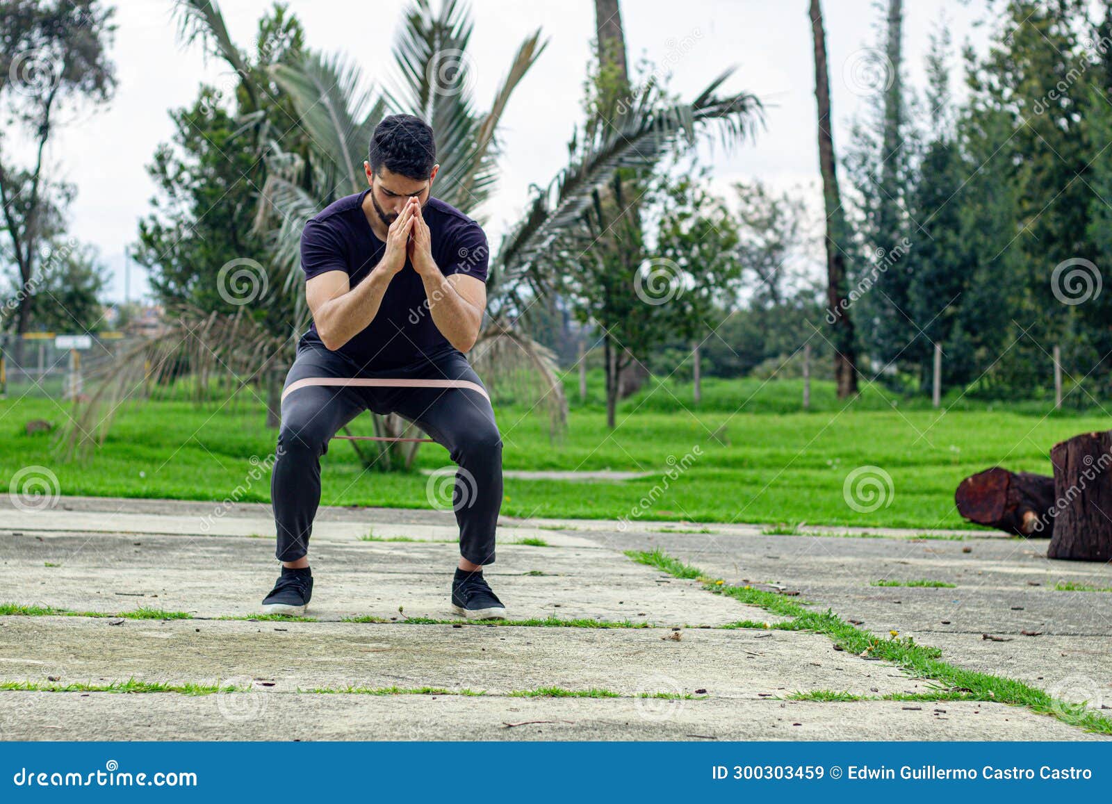 Young Man Training with Elastic Bands, Doing Squat Leg Exercise ...