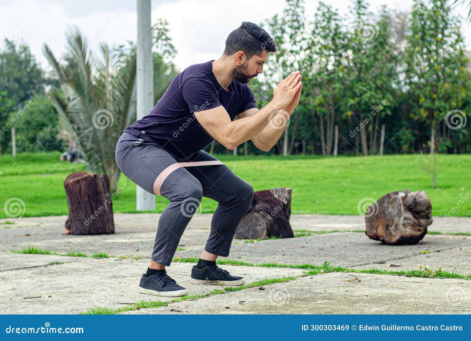 Young Man Training with Elastic Bands, Doing Squat Leg Exercise ...