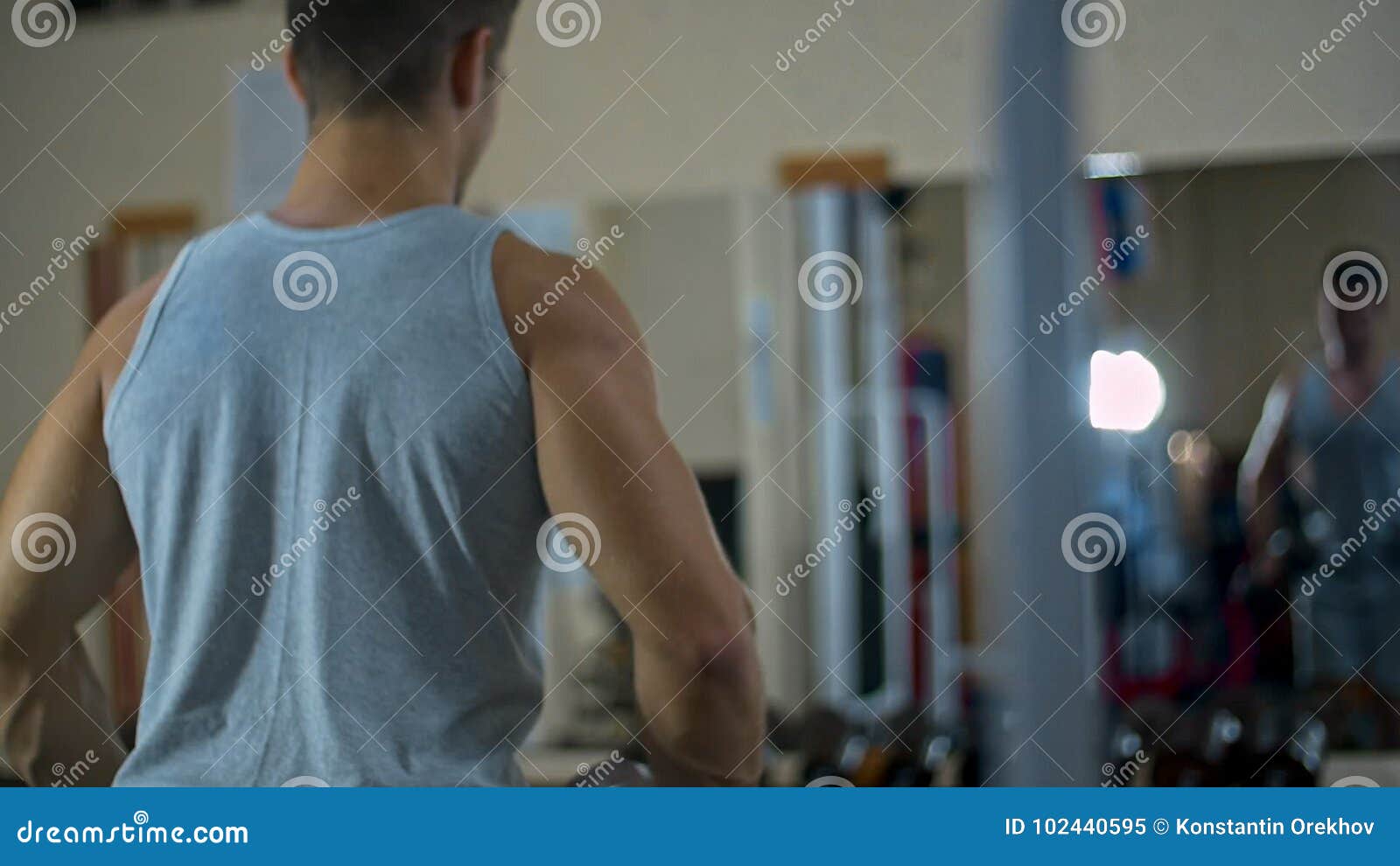 The Man Trains the Biceps and Arms Muscle on the Block Device Stock ...