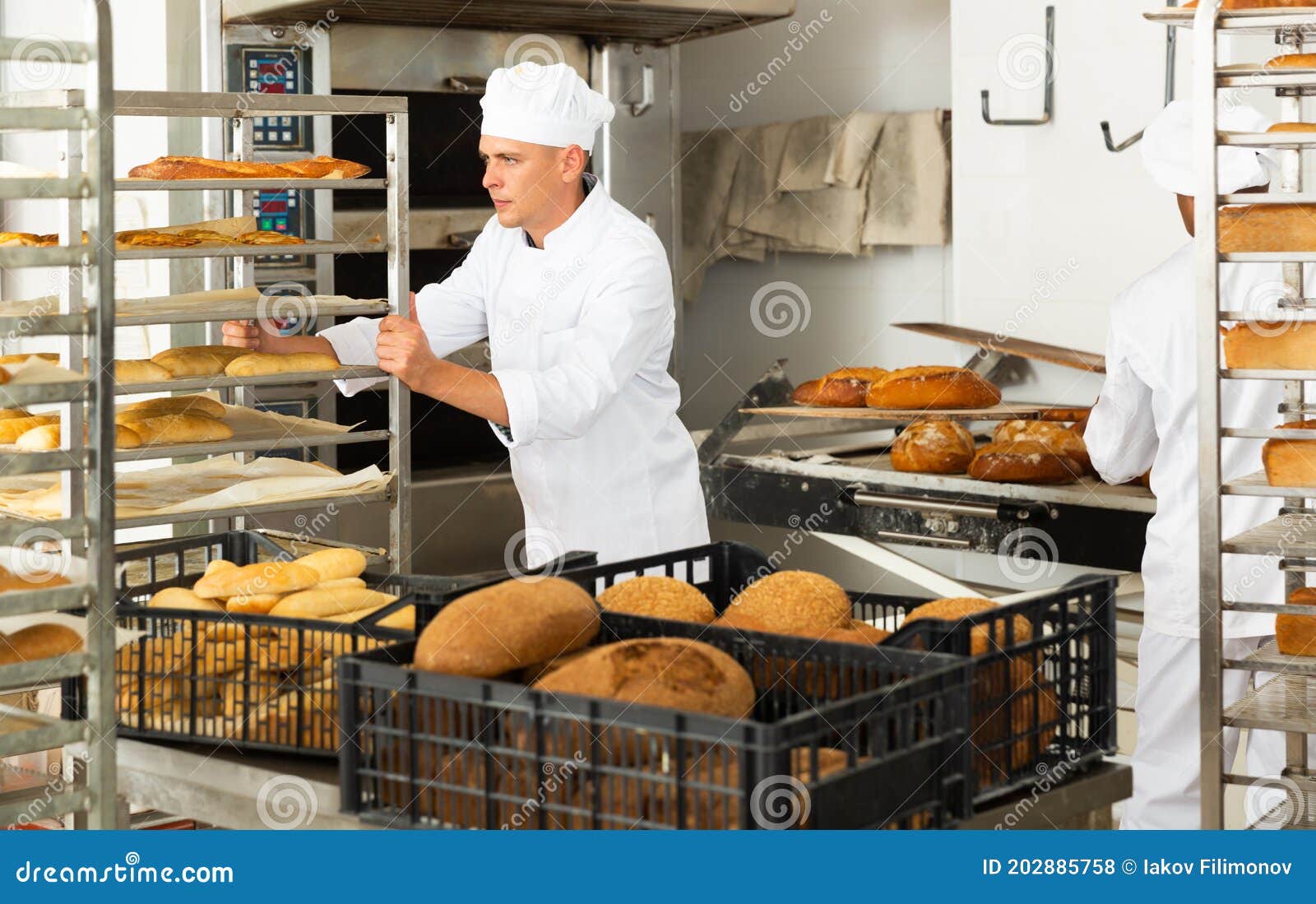 Man Transporting Cart with Bread in Bakery Stock Photo - Image of ...
