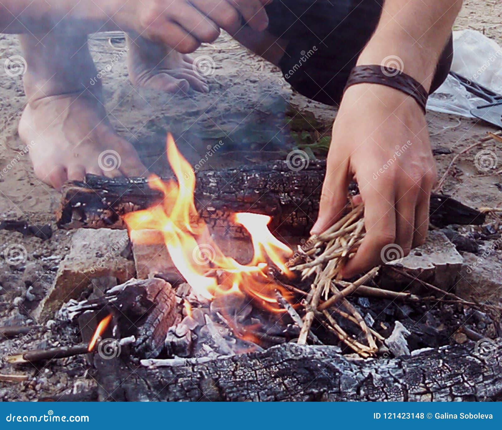 A Man Tries To Light a Fire and Throws Straw into the Fire Stock Photo ...