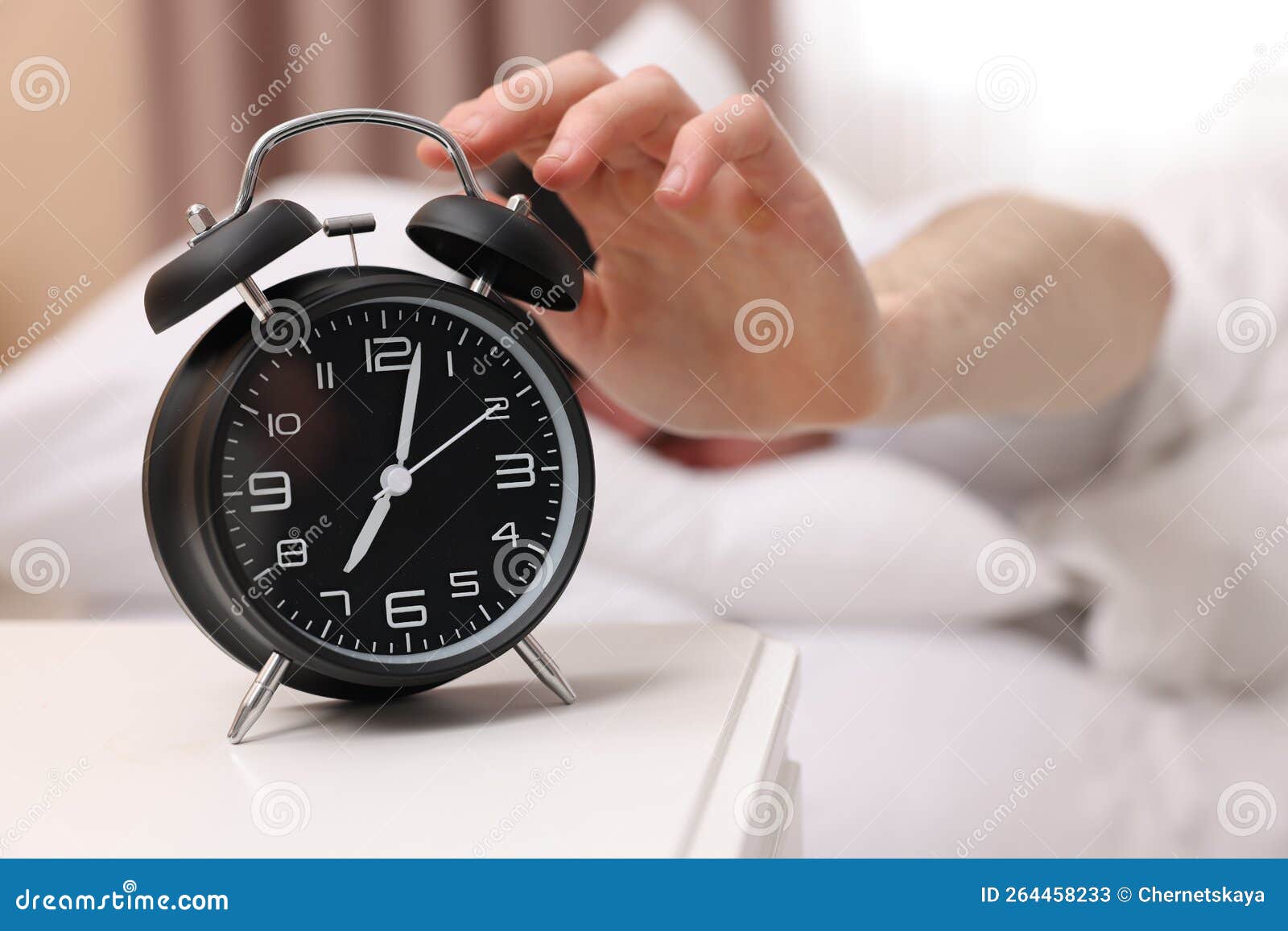 Man Turning Off Alarm Clock In Bedroom Focus On Hand Stock Image