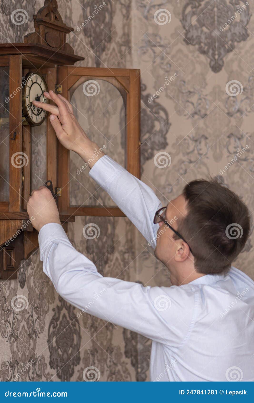 A Man Turns the Hands in an Old Wall Clock. Stock Image - Image of ...