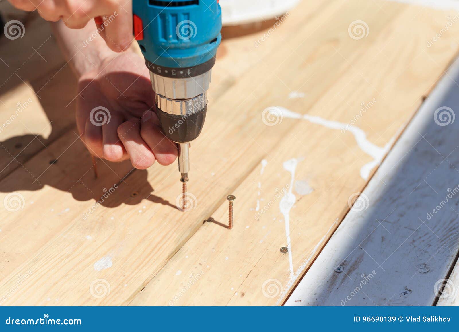 The Man Twists the Screws into the Boards Using a Screwdriver Stock ...