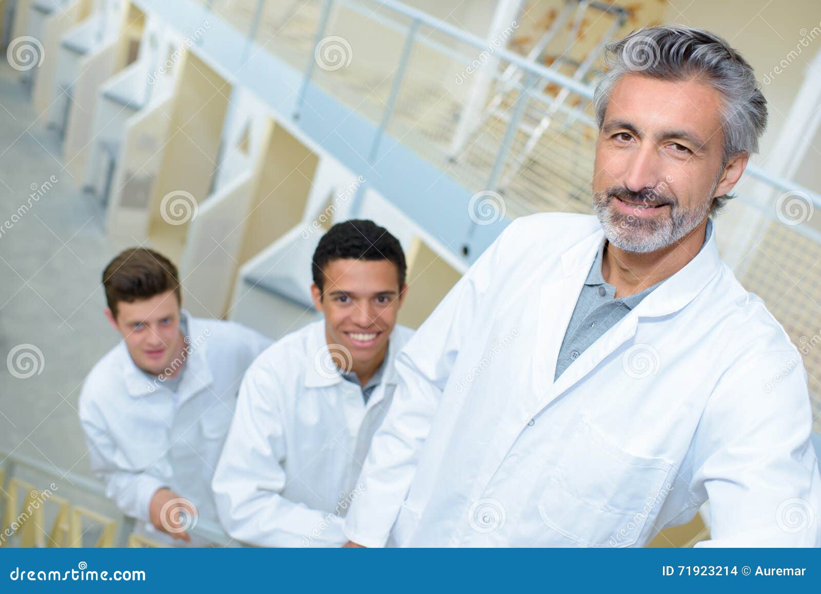 Man with Two Young Men in White Jackets Stock Photo - Image of face ...