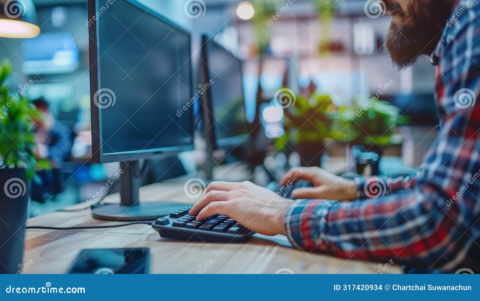 A Man Is Typing On A Computer Keyboard In Front Of A Computer Monitor