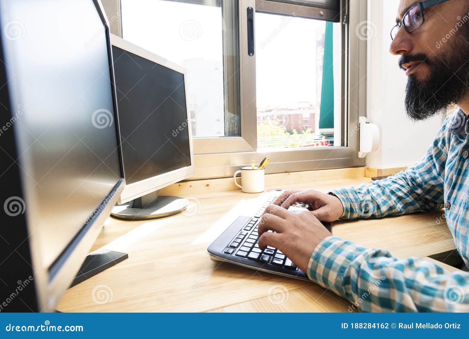 Man Typing on in Front of Two Computer Screens Stock Photo - Image of ...