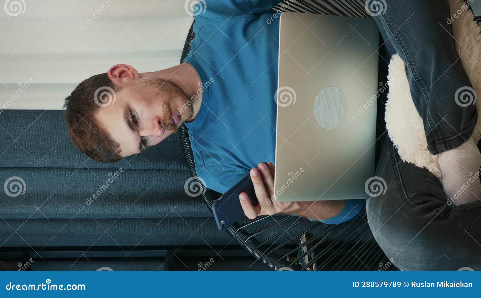 Man Typing Messages on Smartphone during Work on Laptop Computer ...