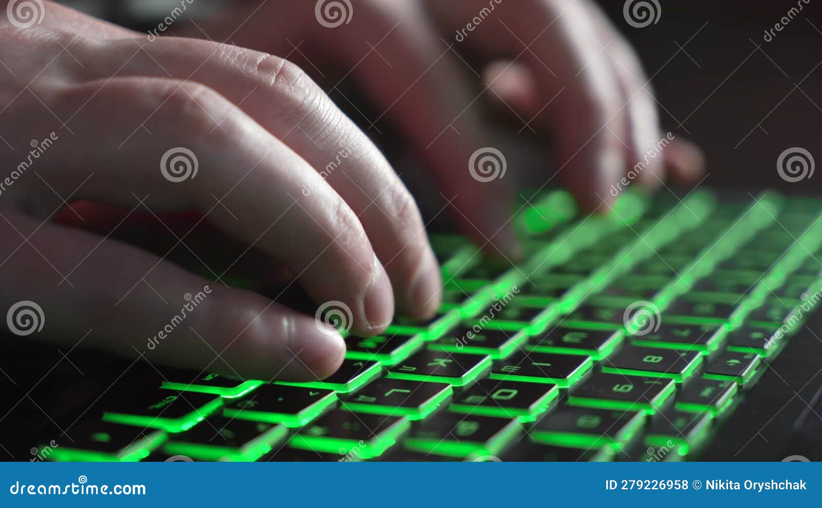 A Man is Typing Text on a Laptop Keyboard with Green Backlight. Close ...