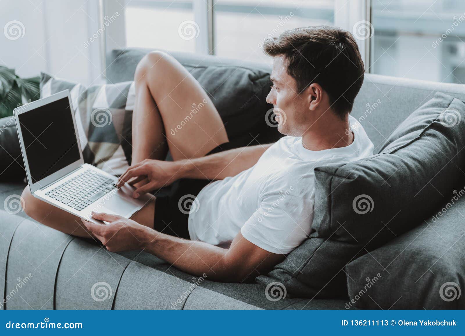 Man in Underwear Lying on the Sofa and Using Modern Laptop Stock Image ... Man in Underwear Lying on the Sofa and Using Modern Laptop Stock Image ...
