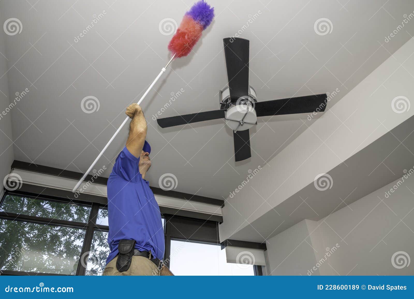 Man in Uniform Dusting a Fan Stock Image - Image of person, house ...