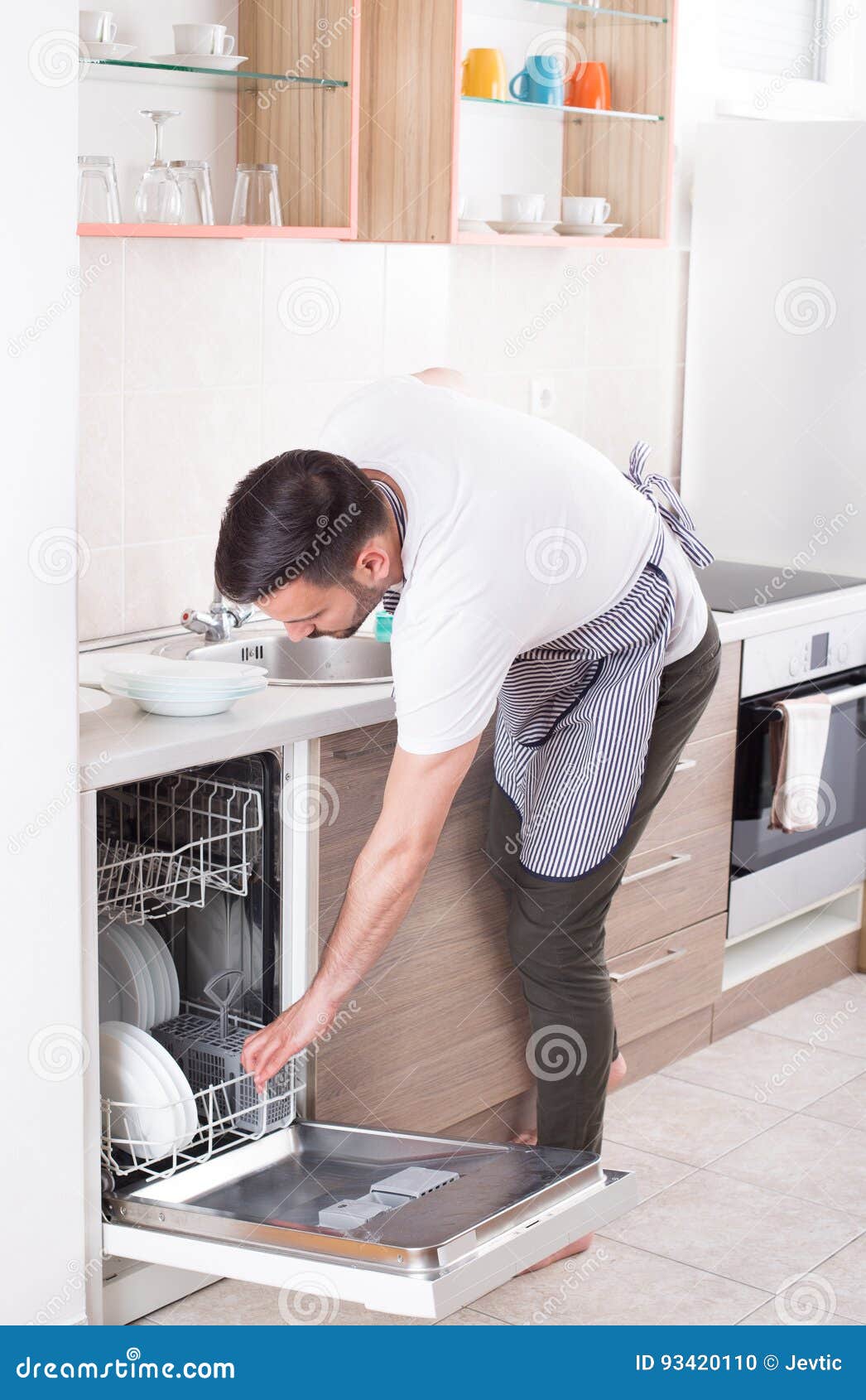 Man unloading dishwasher stock photo. Image of dishware - 93420110