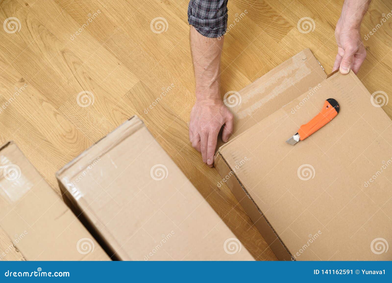 A Man is Unpacking the Cardboard Boxes Stock Image - Image of carton ...