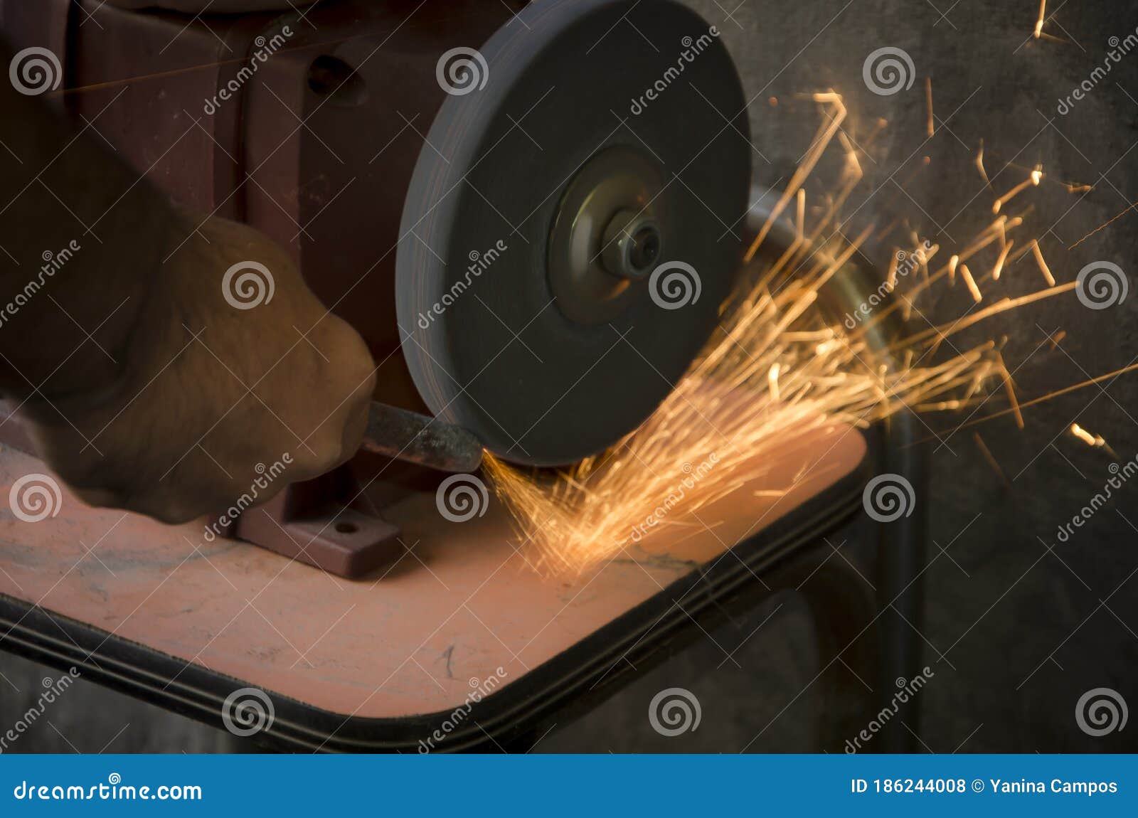 Man use a bench grinder. stock photo. Image of machine - 186244008