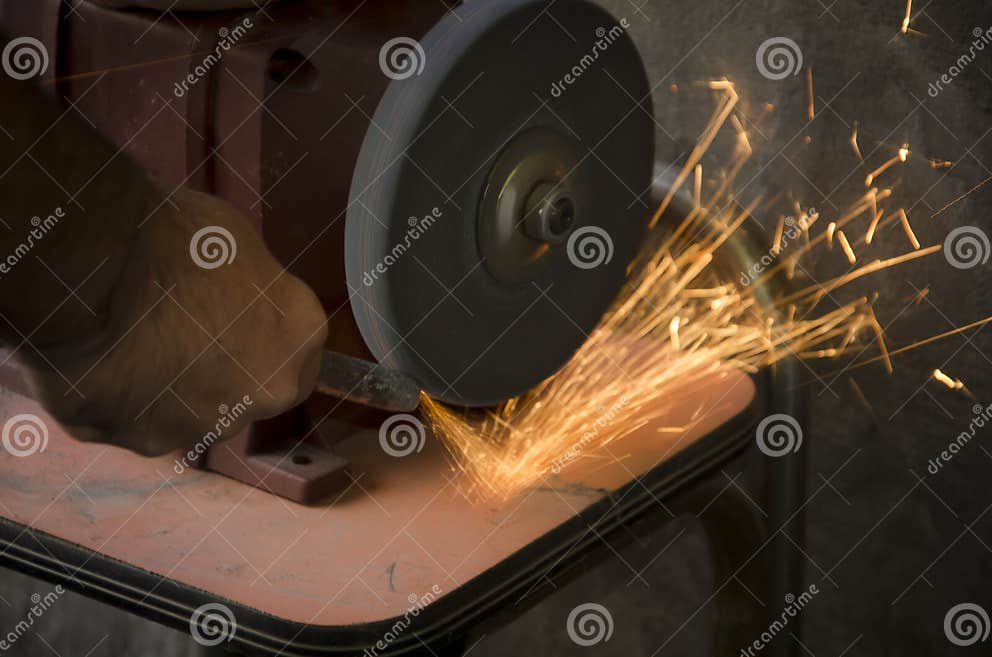 Man use a bench grinder. stock photo. Image of machine - 186244008