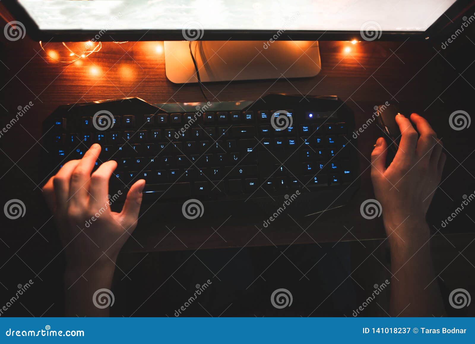 Man Uses a Computer at Night, Hands on the Keyboard and a Mouse Over ...