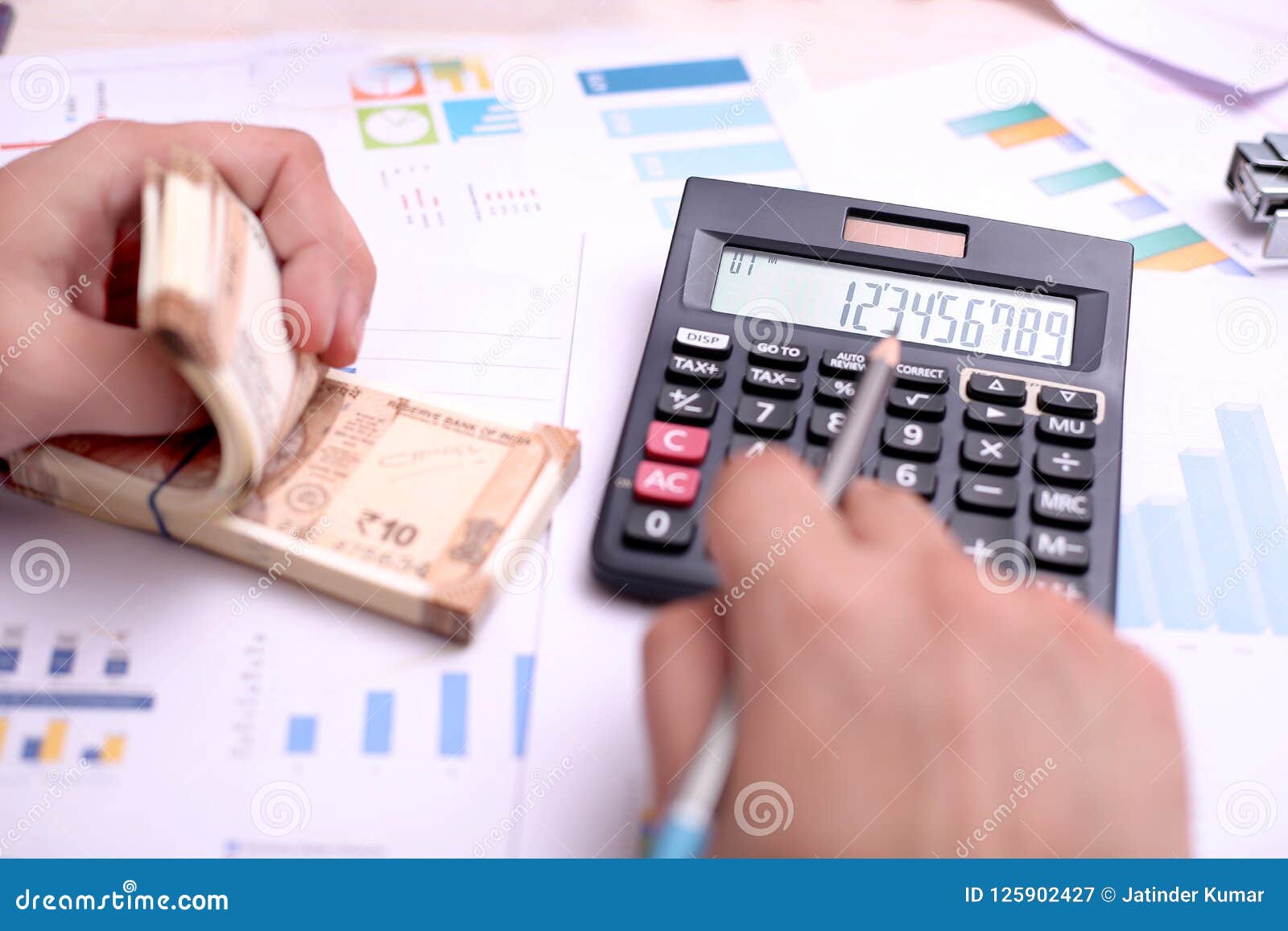 Man is Using Calculator with Holding Pencil and Indian 10 Rupee Notes ...