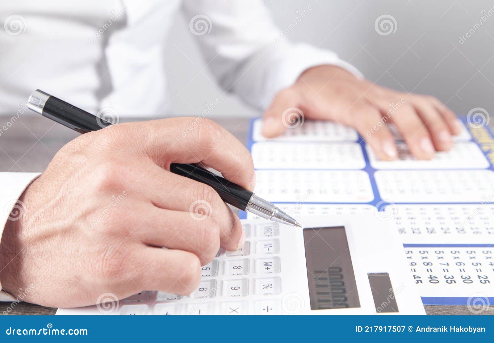 Man Using Calculator with a Multiplication Table Stock Image - Image of ...