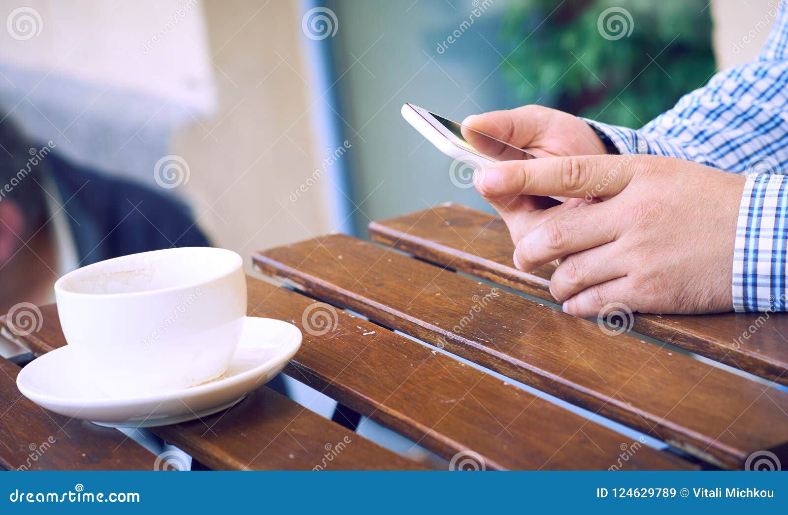 Man Using a Cell Phone on Cafe Terrace and Drinking Coffee. Man Drinks ...
