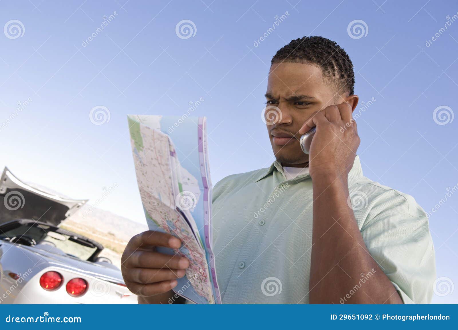 Man Using Cell Phone while Looking at Map Stock Photo - Image of sunny ...